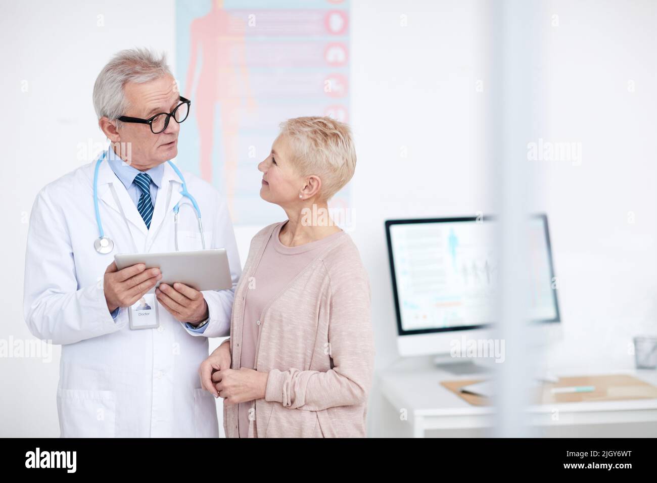 High-qualified senior gray-haired doctor in eyeglasses and lab coat ...