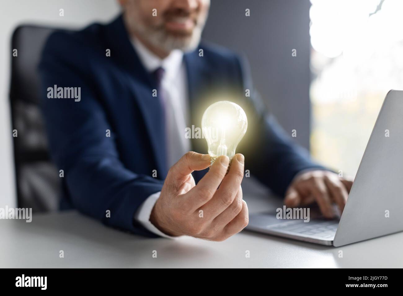 Business Innovations. Businessman Holding Illuminated Light Bulb While ...