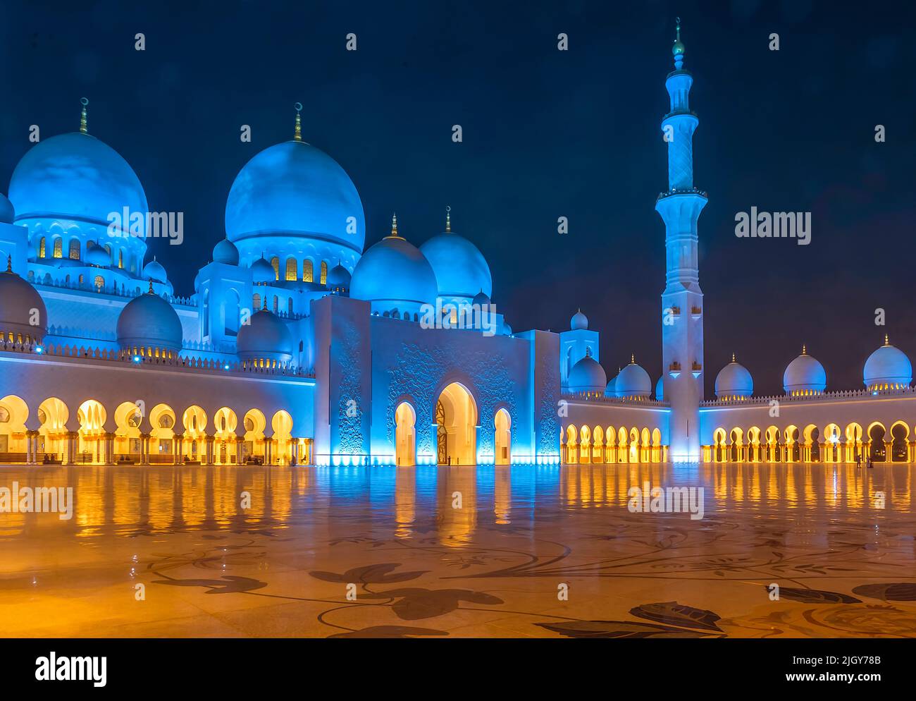 Courtyard view of the blue illuminated Sheikh Zayed Grand Mosque in Abu ...