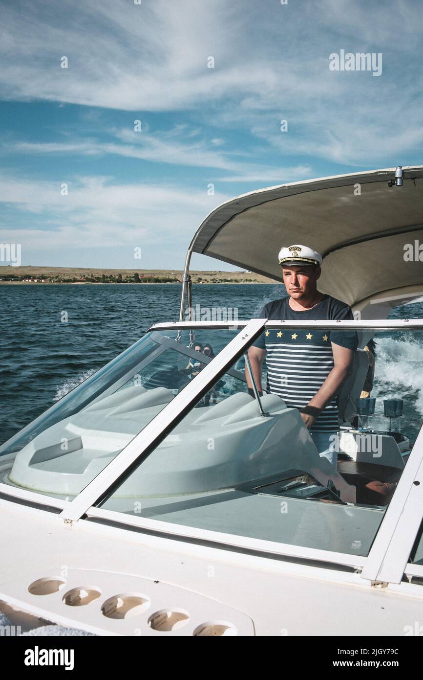 the captain of the yacht at the helm controls the boat on the water ...