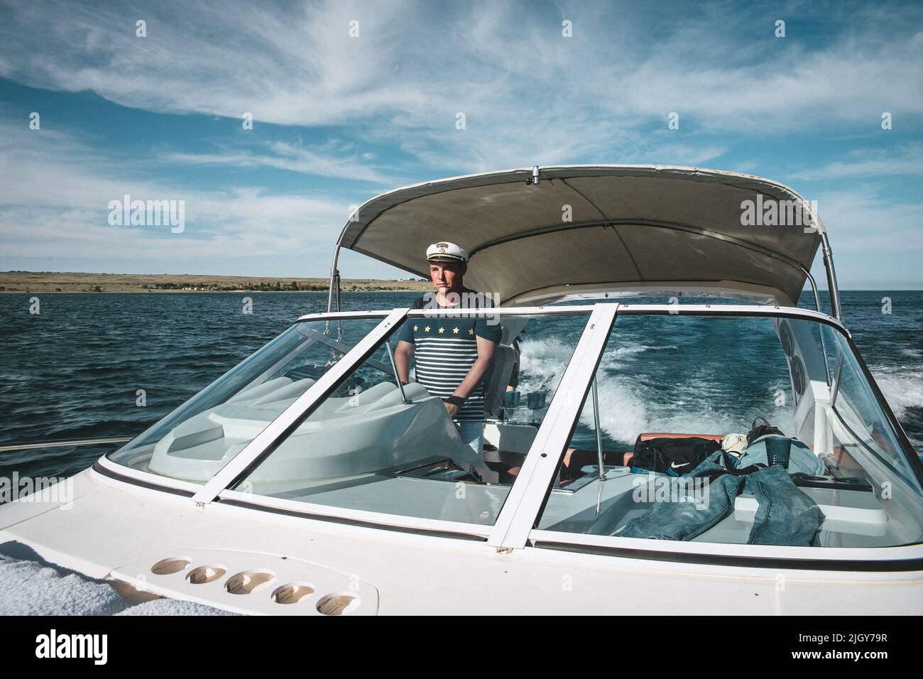 the captain of the yacht at the helm controls the boat on the water ...