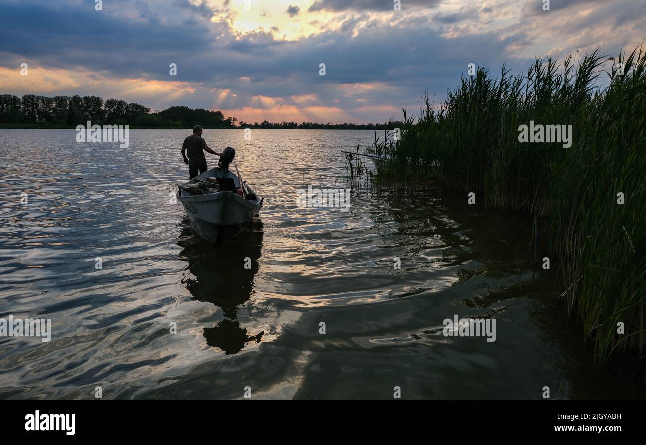Ketzin, Germany. 13th July, 2022. A fisherman stands by his fishing ...