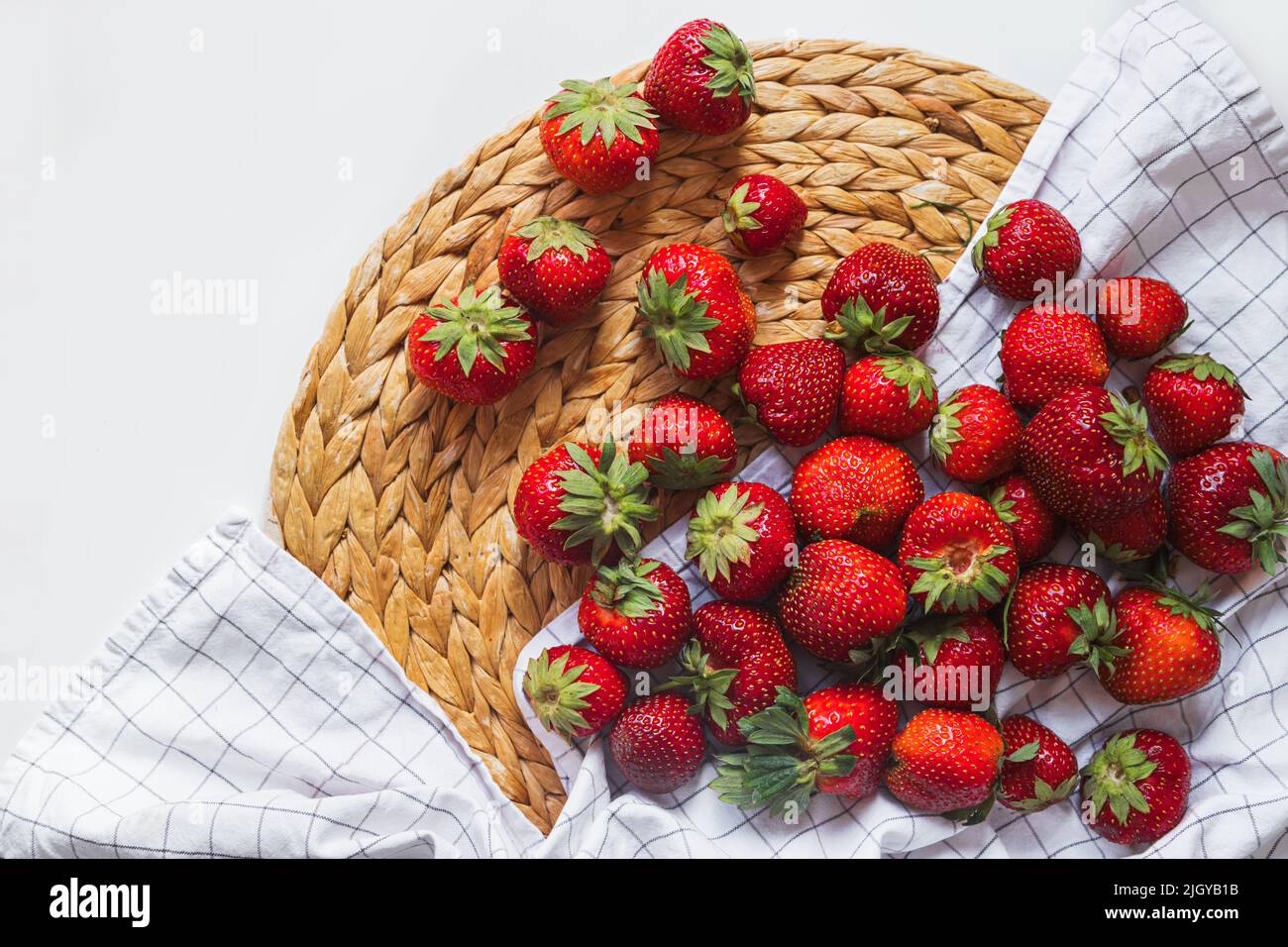 Ripe red strawberry on checkered fabric and wicker rug, summer berry ...