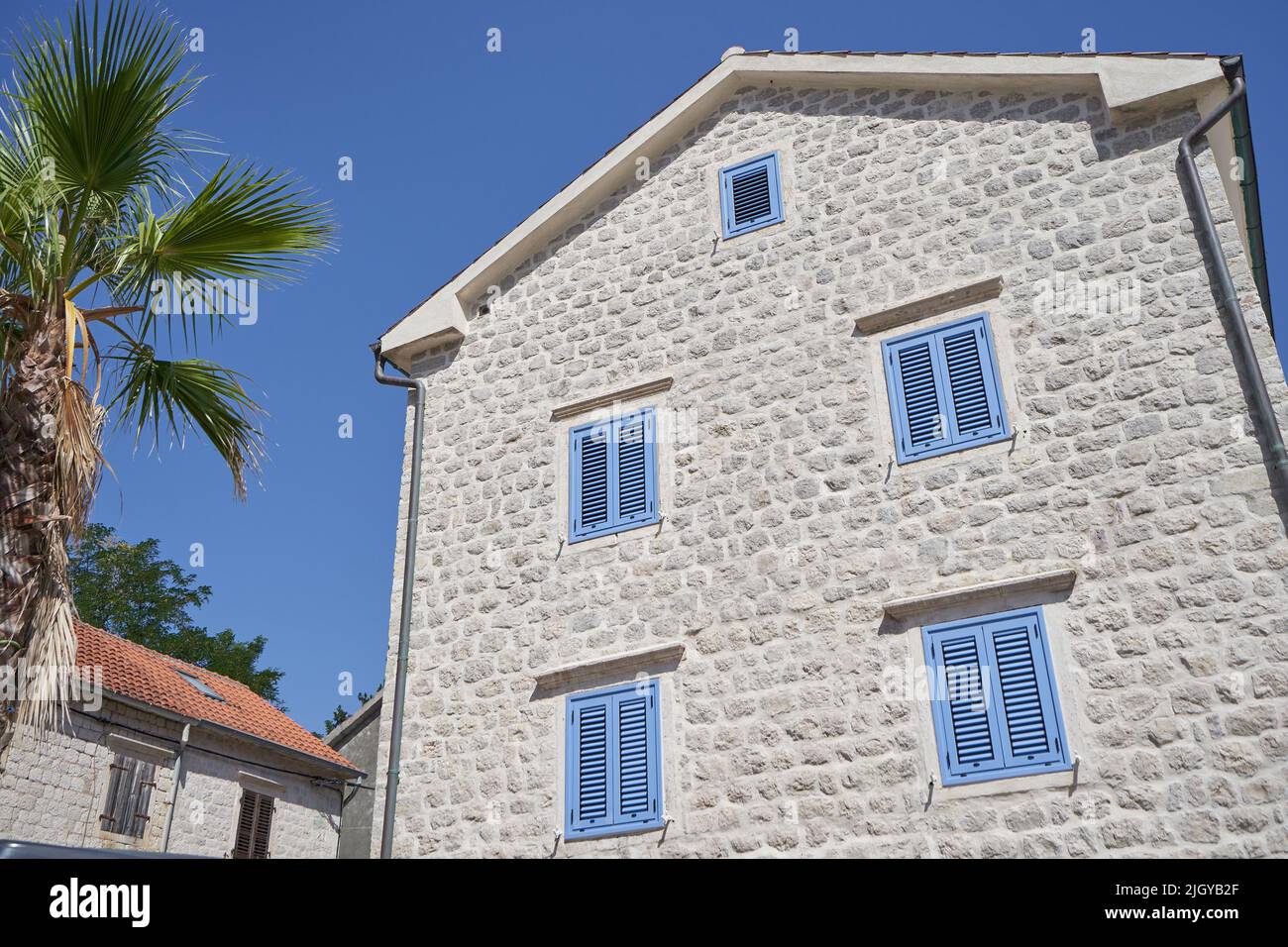 Stone house with blue shutters in a European village Stock Photo - Alamy