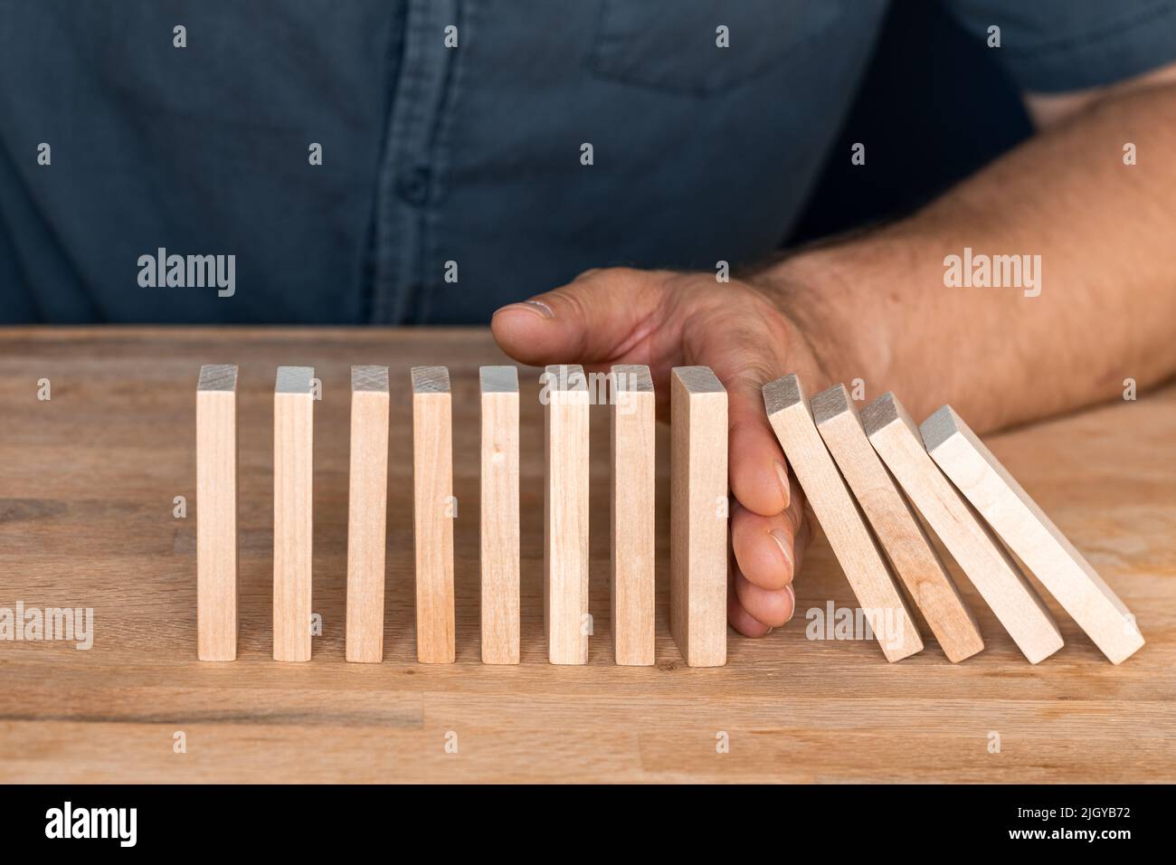 Businessman hand stop falling off wood block, planing and strategy ...