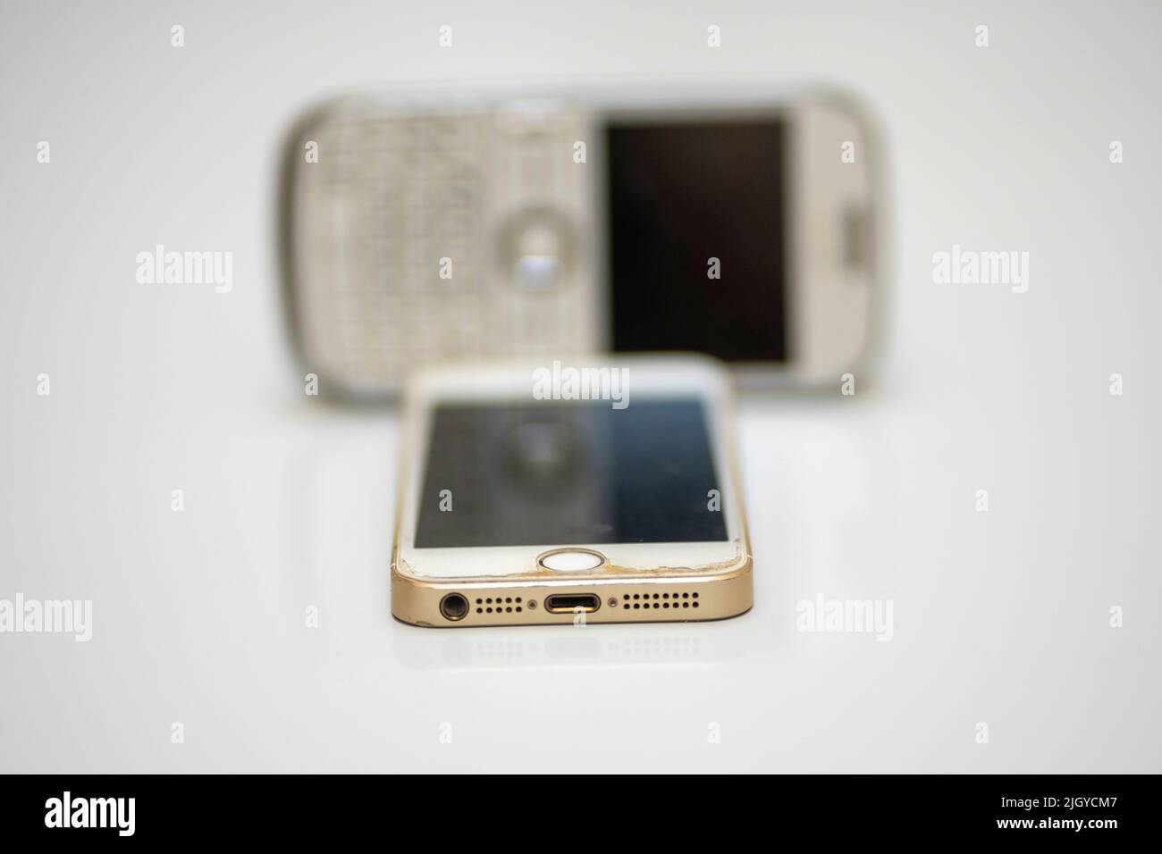 Two disposed damaged smartphones on a white background Stock Photo - Alamy
