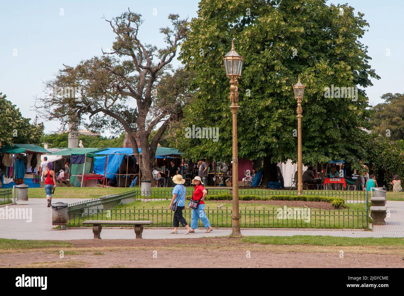 Two women walking in the park with open-air markets Stock Photo - Alamy