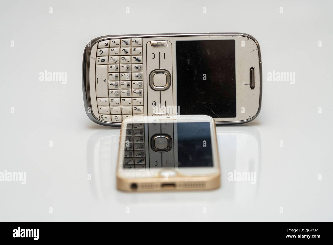 Two disposed damaged smartphones on a white background Stock Photo - Alamy