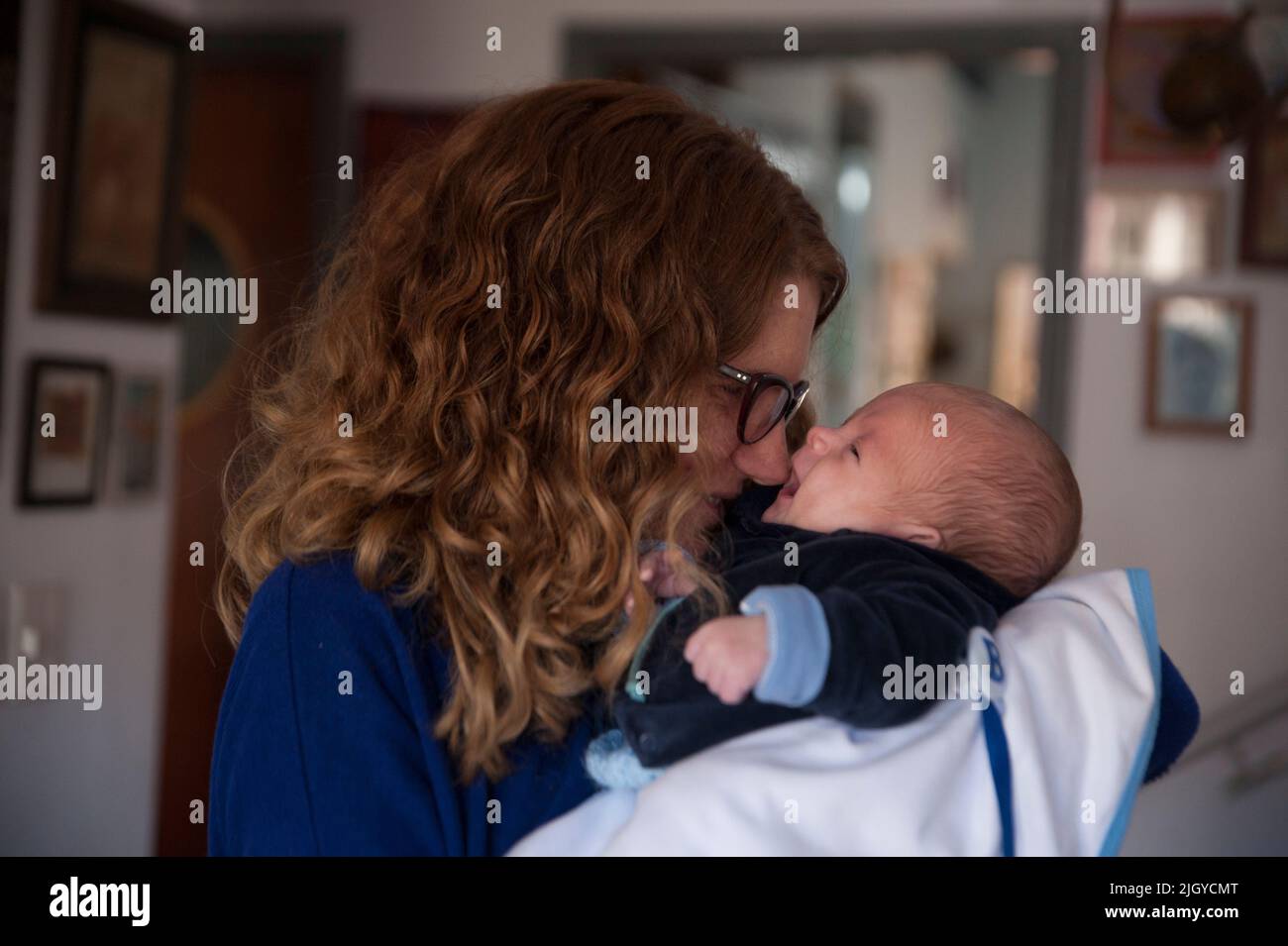 A ginger mother cuddling with her baby in the room Stock Photo - Alamy