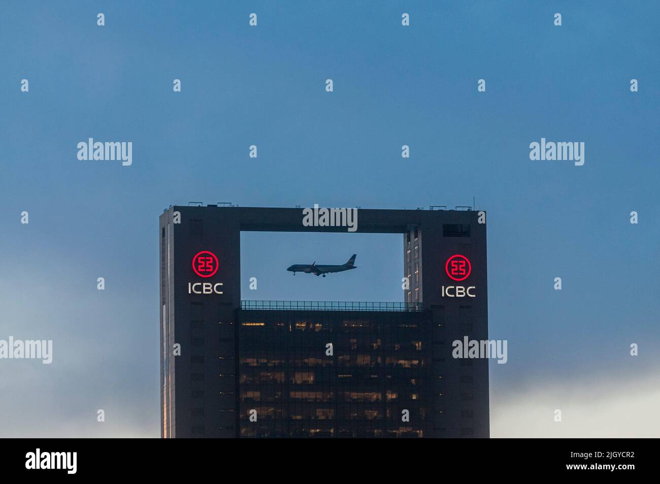 A plane in flight through a frame of a building by the ICBC Bank Stock ...
