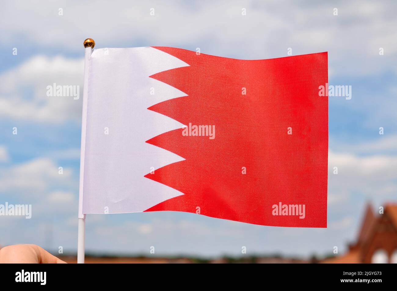 close up of national flag of bahrain on blue sky background ,red and ...
