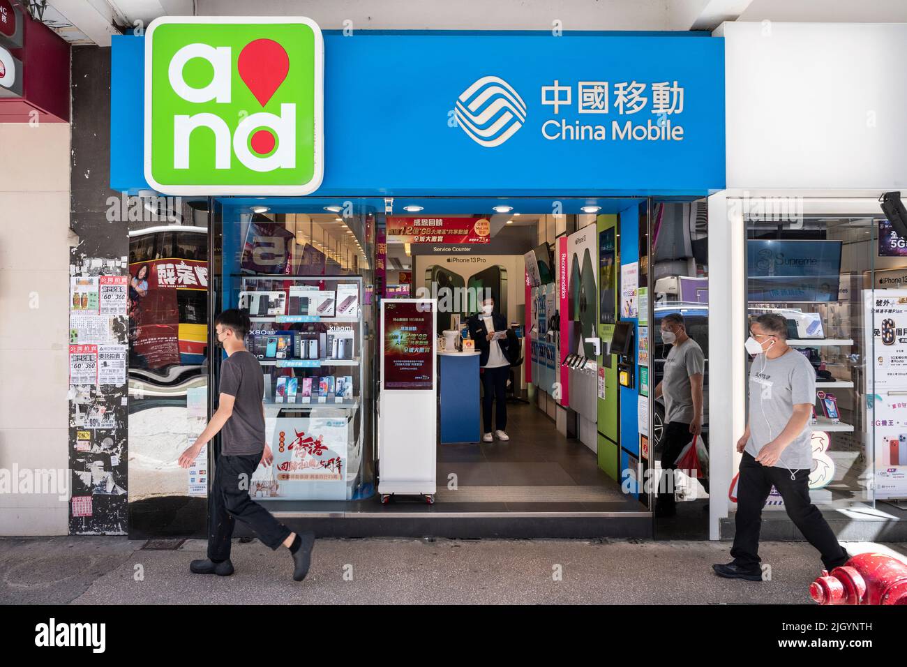 Pedestrians walk past Chinese state-owned telecommunication corporation ...