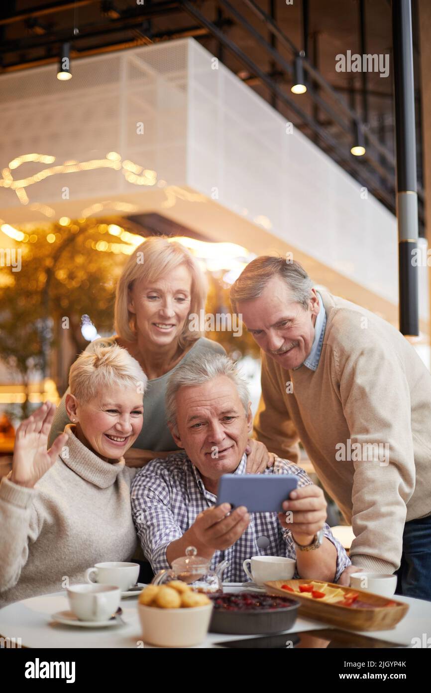 Group of positive senior former classmates communicating with friends ...