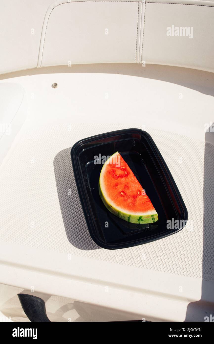 watermelon slice in Tupperware on deck of boat Stock Photo - Alamy