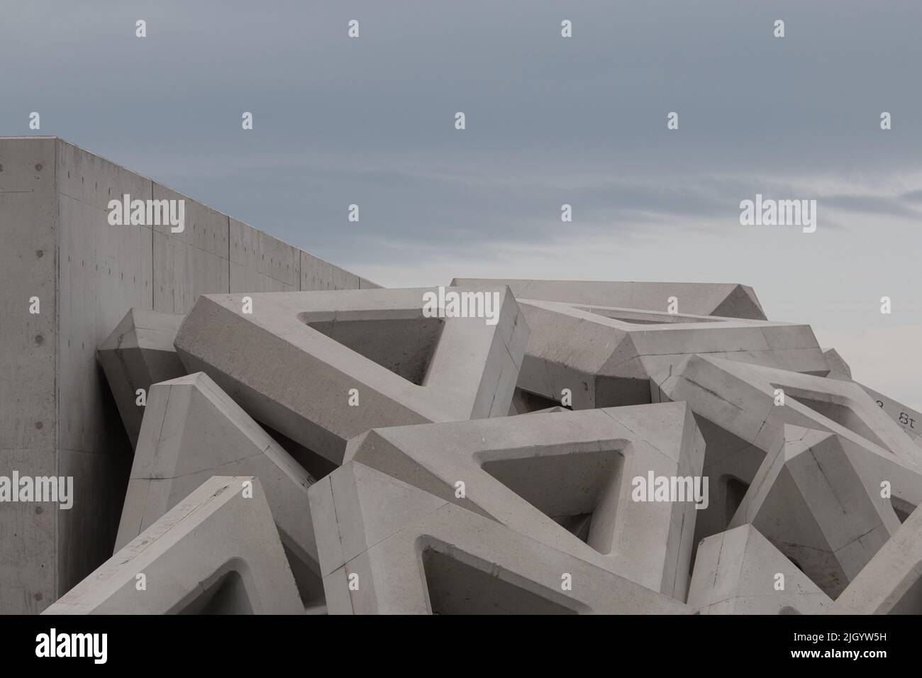 New concrete tetrapods against a harbour wall Stock Photo - Alamy
