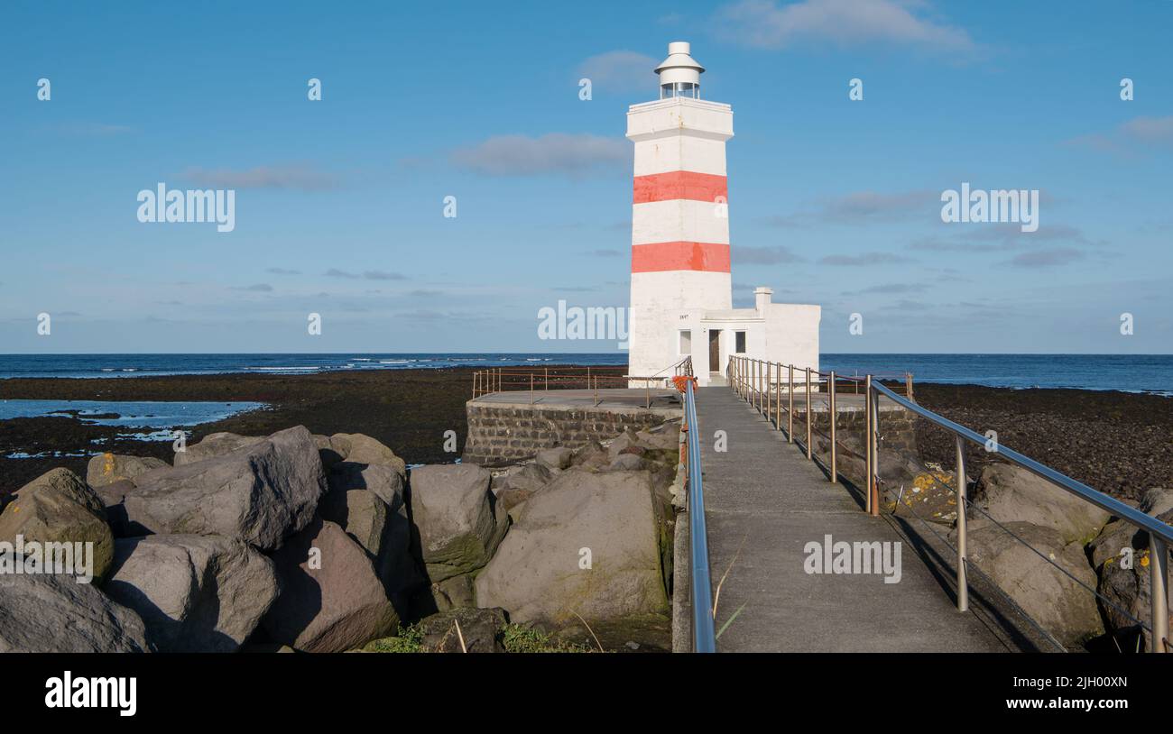There are two lighthouses standing side by side at the tip of the ...