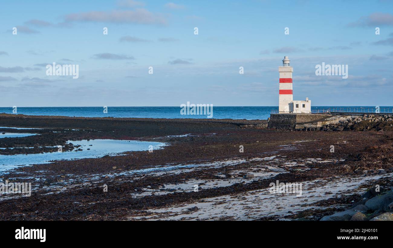 There are two lighthouses standing side by side at the tip of the ...