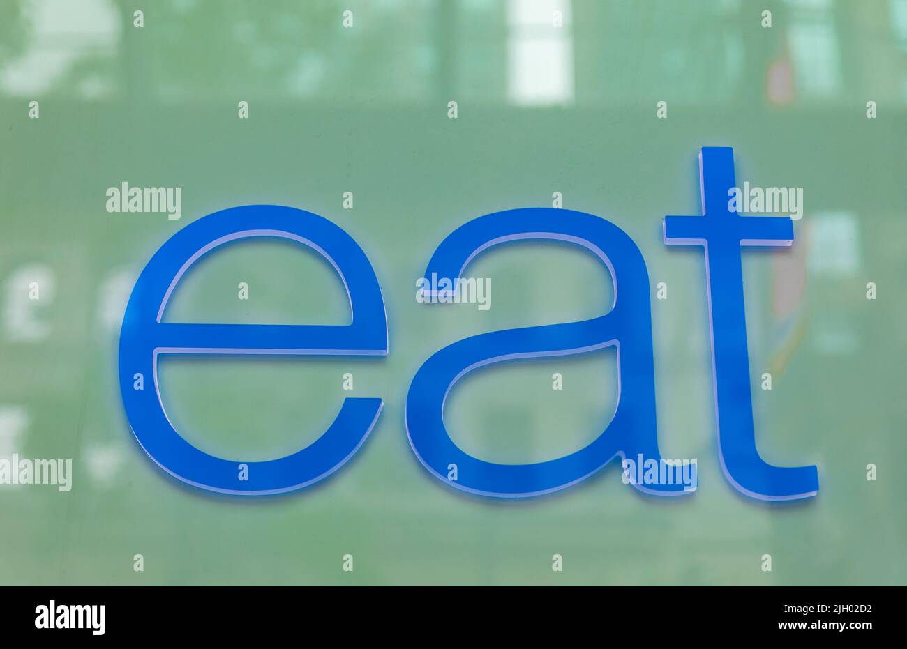 'eat' sign on a glass wall backdrop. Exterior signage and logo Eat here ...