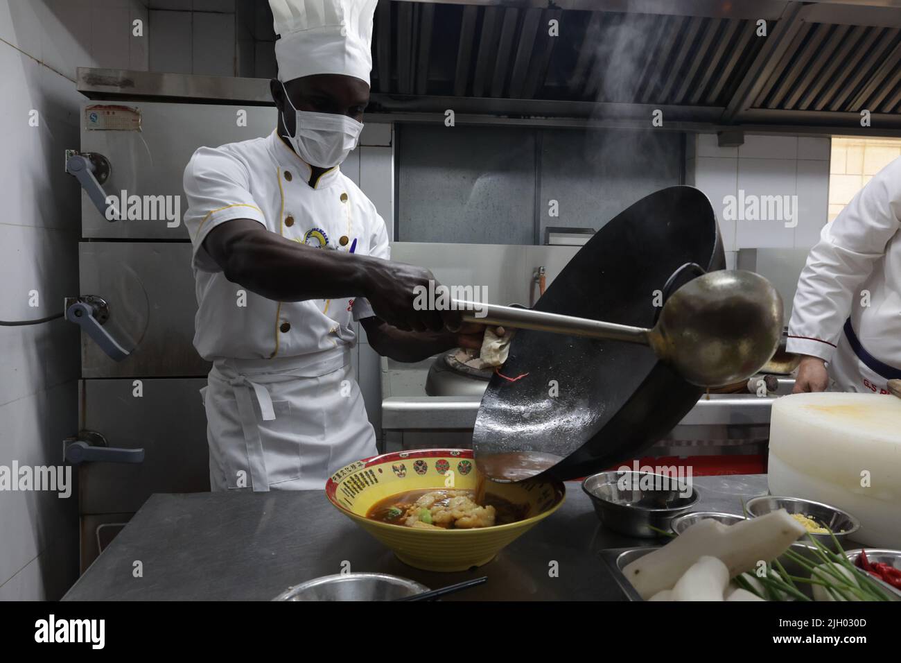 Accra, Ghana. 11th July, 2022. A Ghanaian chef cooks a Chinese dish in ...