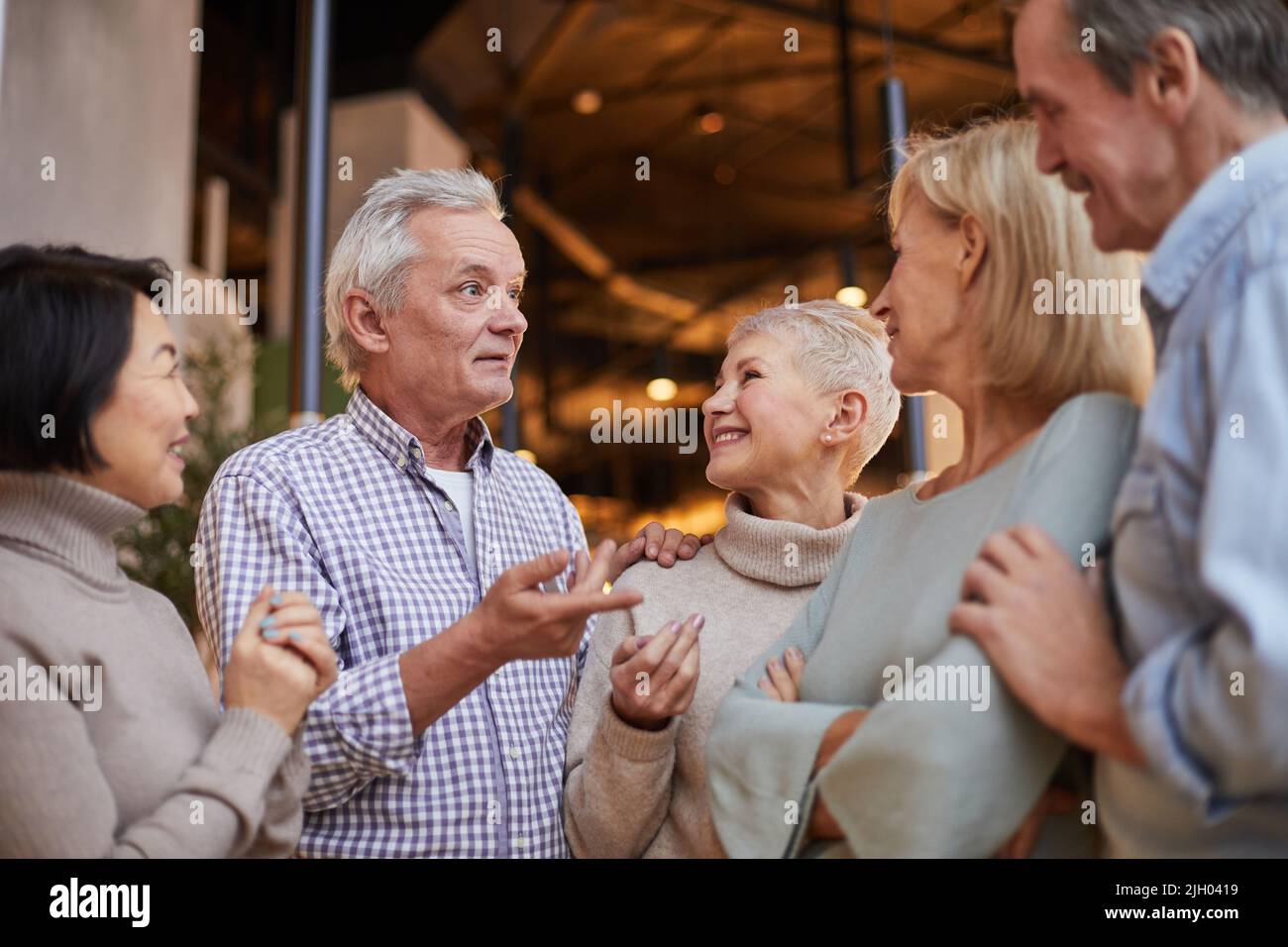 Group of emotional elderly friends in casual clothing standing in ...