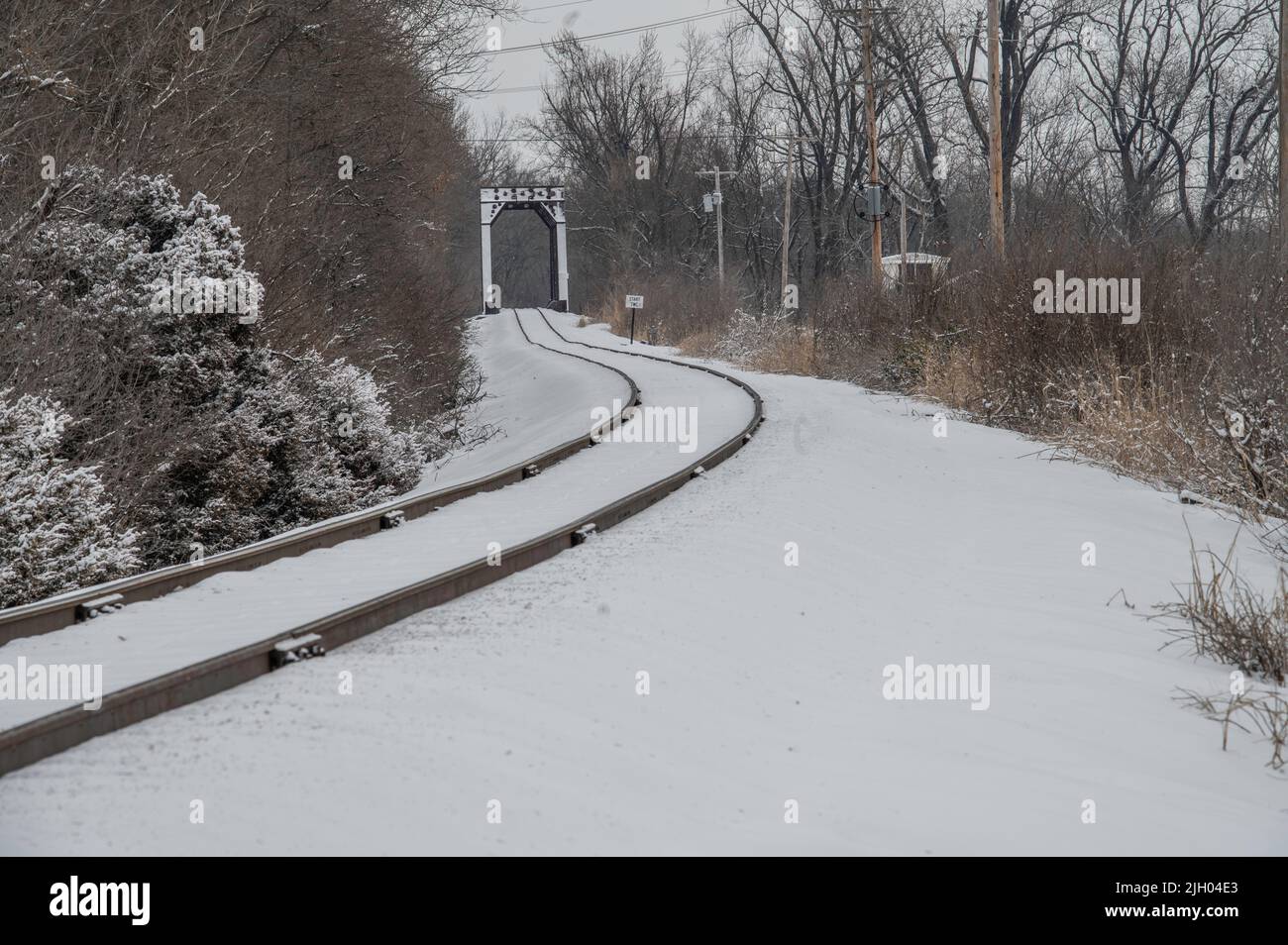 A railroad between snowy path in the forest Stock Photo - Alamy