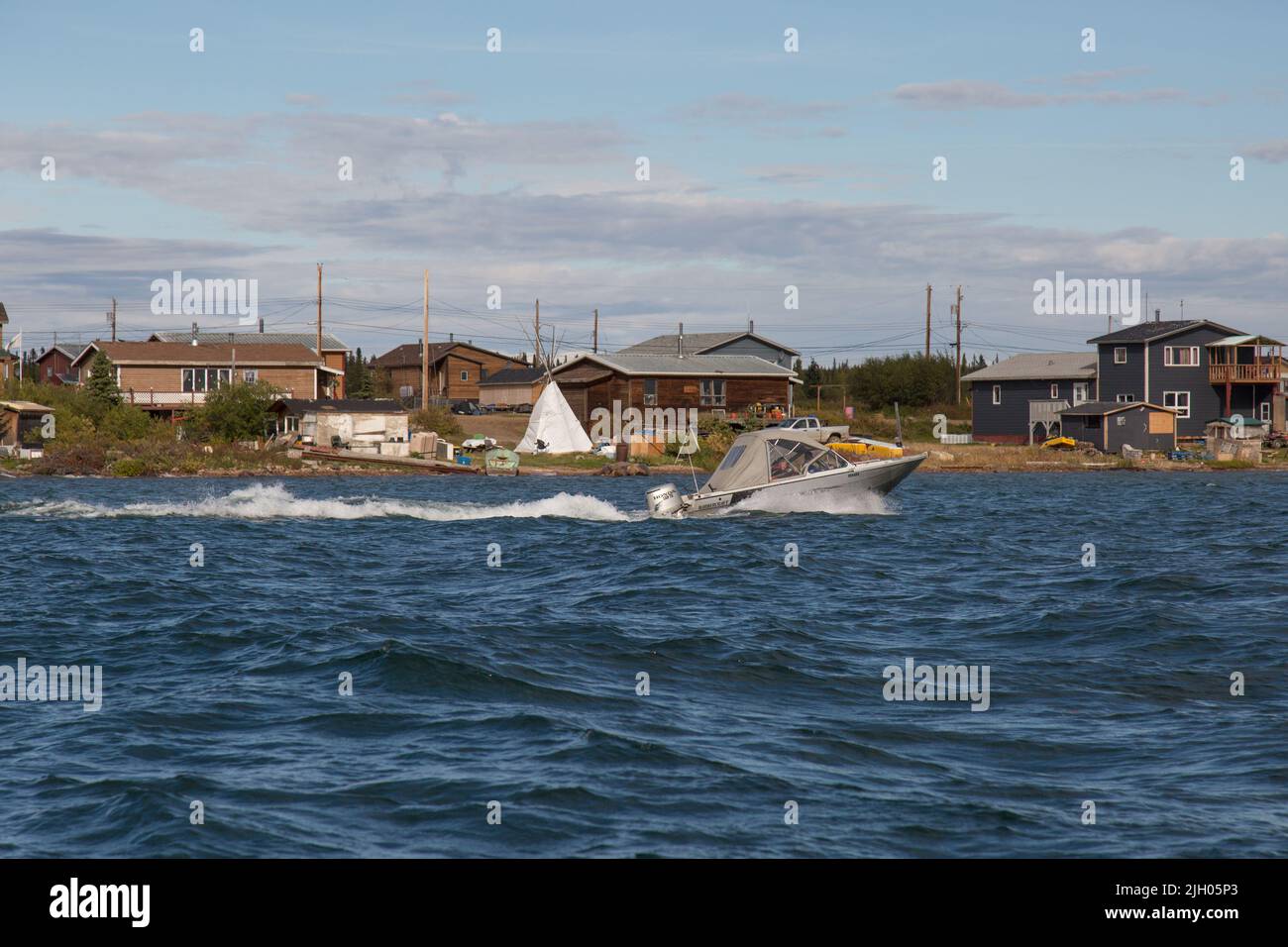 Boat on Great Bear Lake, with a view of the Indigenous community of ...