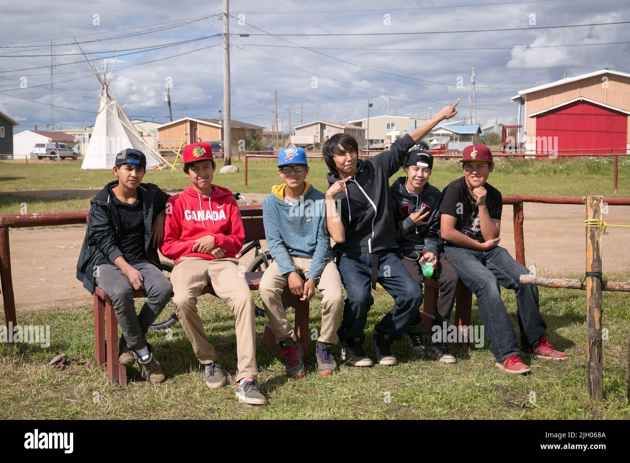 Group of Indigenous Dene boys sitting on bench in summer, in the ...