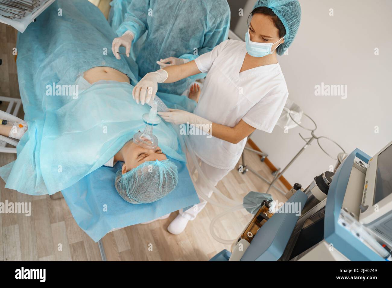 Doctor anesthesiologist holding breathing mask on patient face during ...