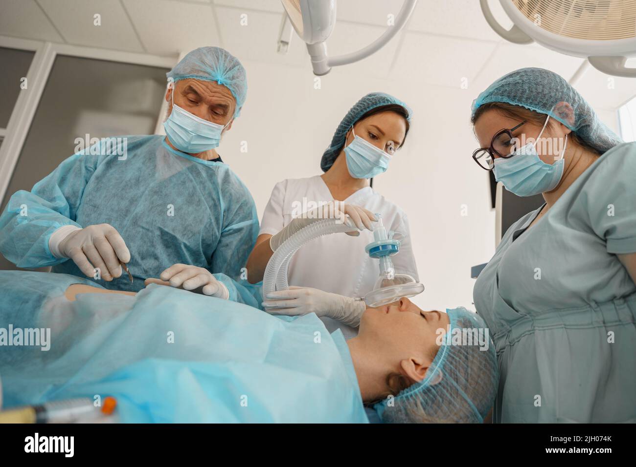 Well-trained anesthesiologist follows the patient during the surgery in ...