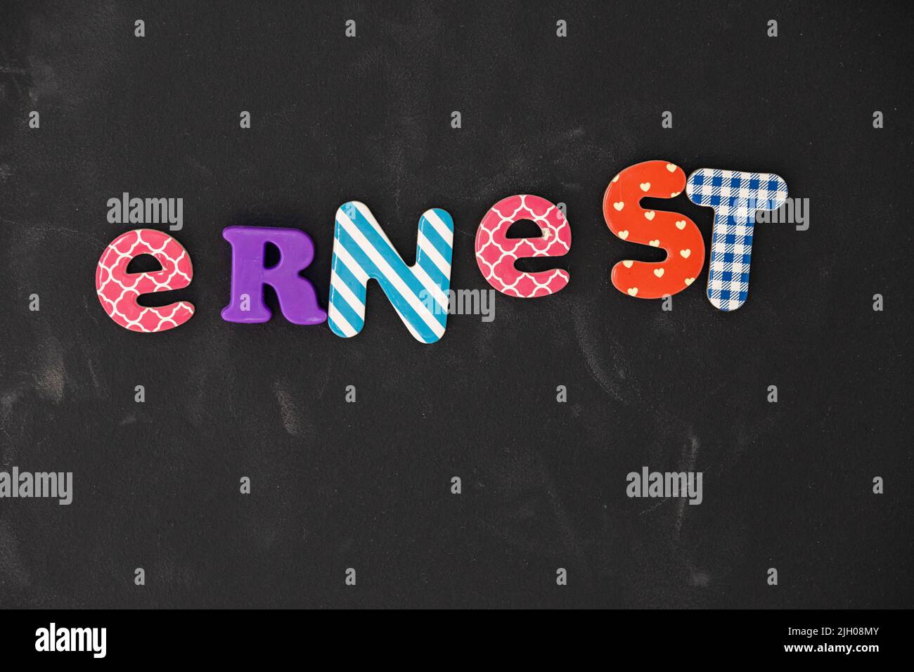 A black magnetic wall with colorful letters spelling "Ernest Stock ...