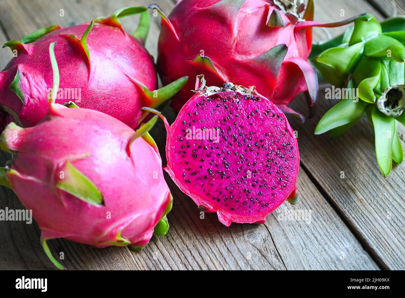 pink purple dragon fruit cut half on wooden with pitahaya background ...