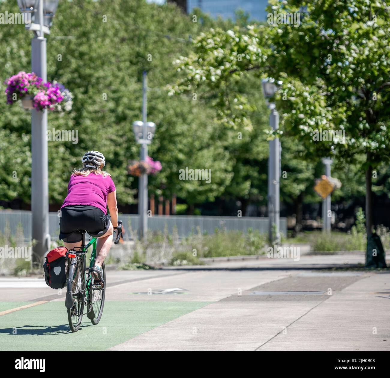 Slender woman on a bike rides a bicycle along the concrete city ...