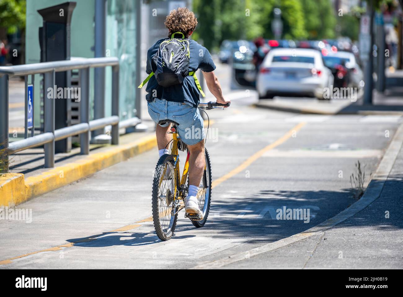 A man on a bike pedals a bicycle on a dedicated path for cyclists ...