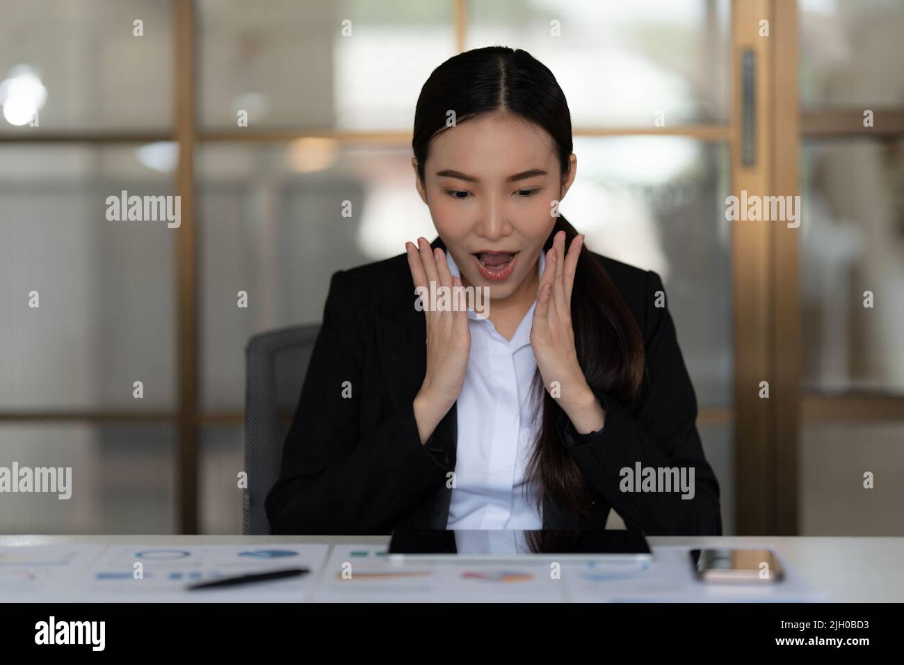 Portrait of Businesswoman surprise while checking turnover budget of ...