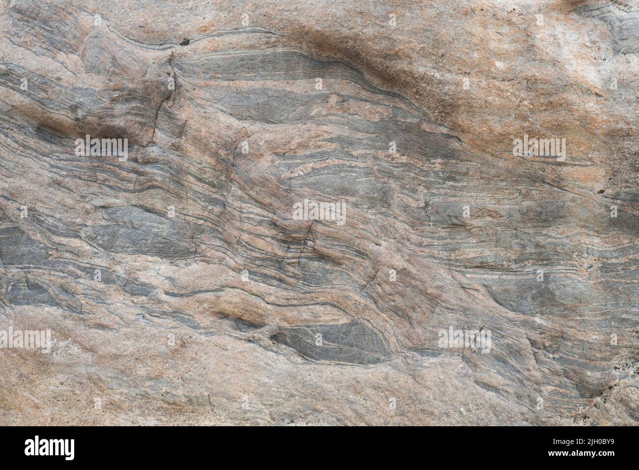 Side view of a rocky surface showing various strata and rough texture ...