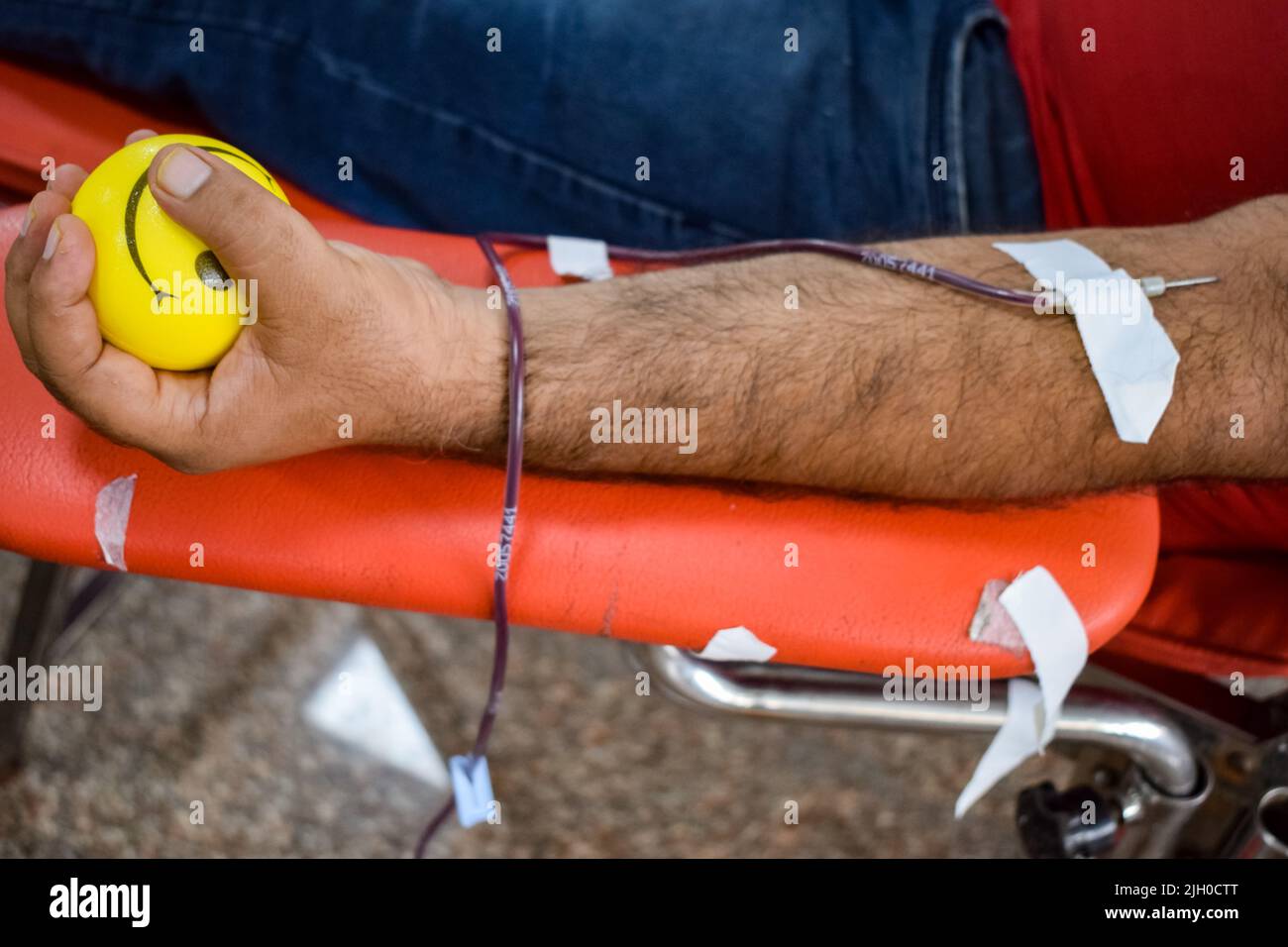 Blood donor at Blood donation camp held with a bouncy ball holding in ...