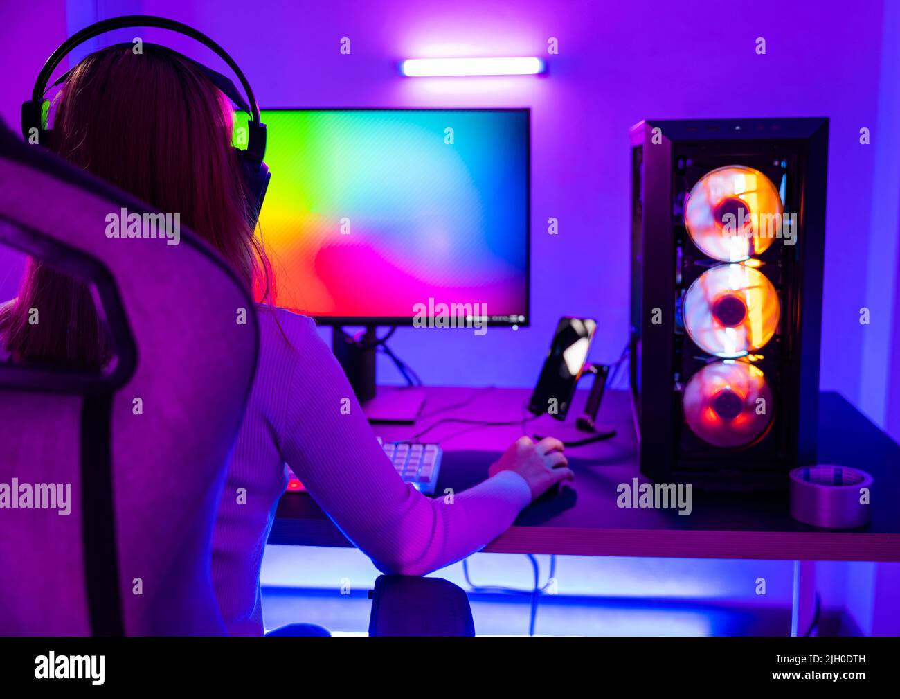 Asian professional gamer playing online video game on desktop computer ...