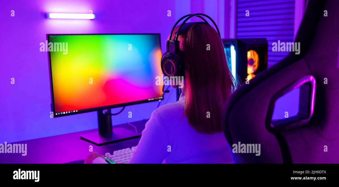 Asian professional gamer playing online video game on desktop computer ...