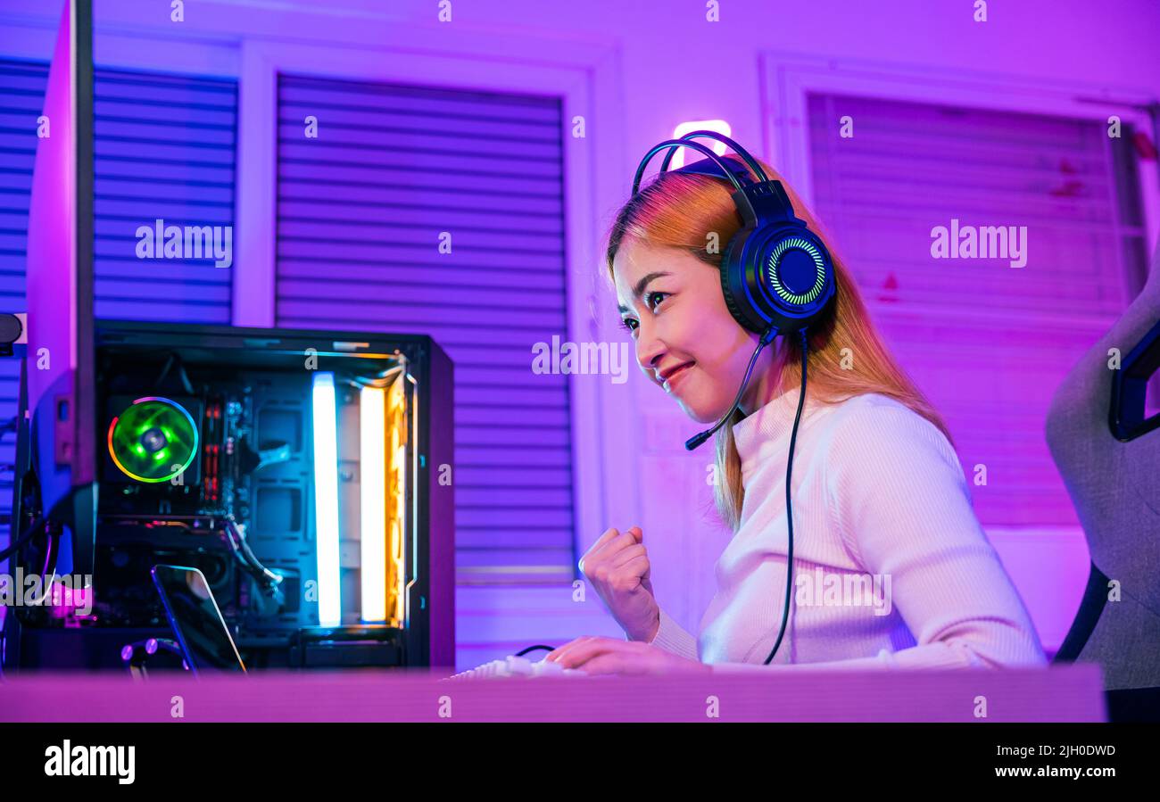 Winning Victory. Asian gamer playing online video game excited on ...