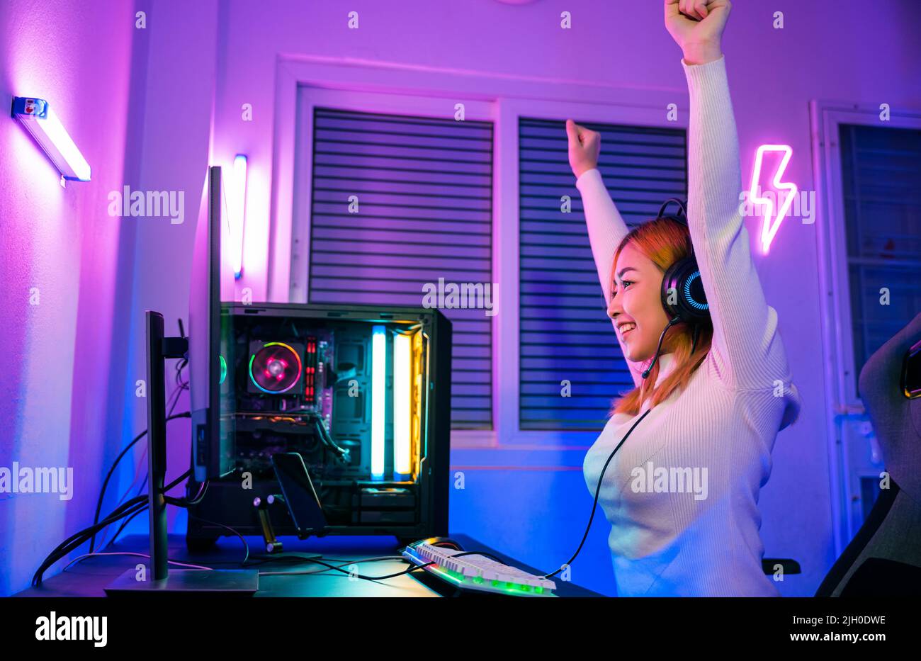 Winning Victory. Asian gamer playing online video game excited on ...