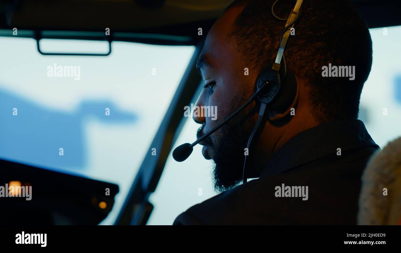 African american copilot preparing to takeoff and fly plane, using ...