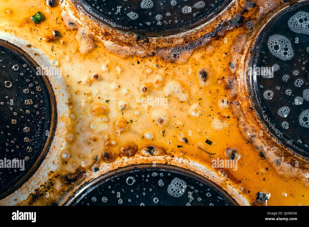 A very heavily soiled old electric kitchen stove in burnt brown soot ...