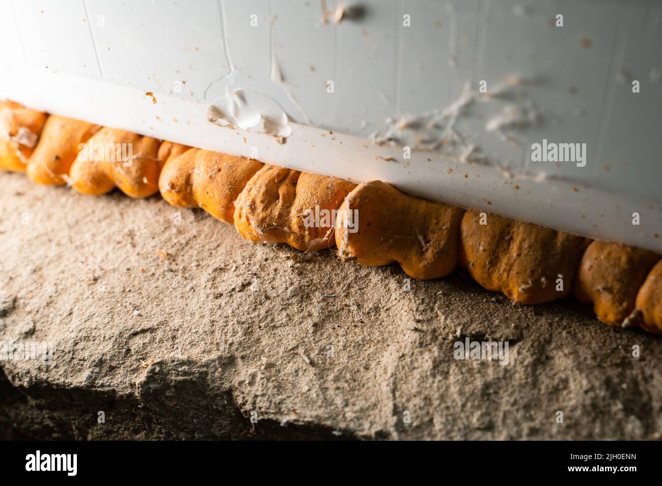 Orange old polyurethane foam between wall and plastic window close-up ...
