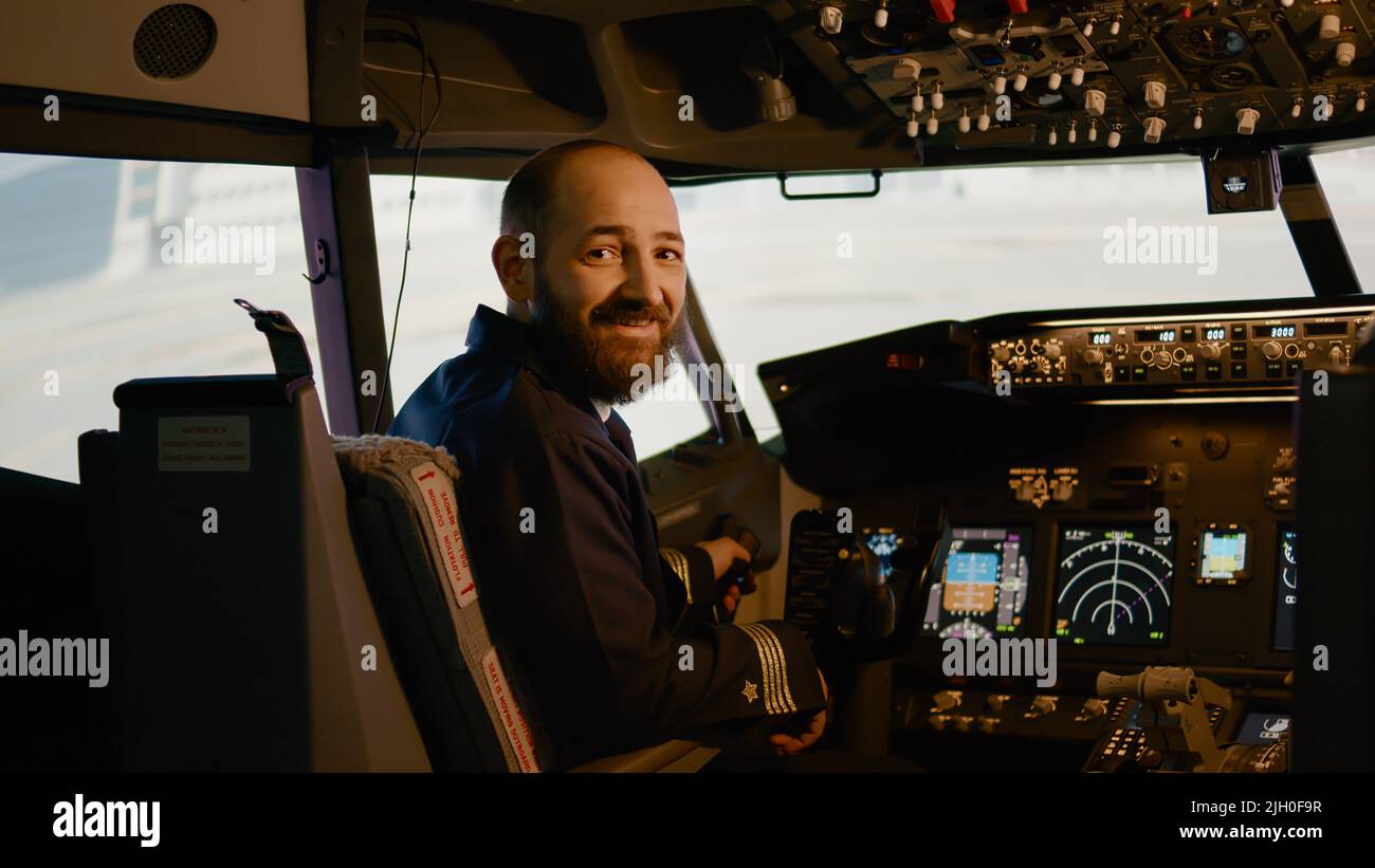 Portrait of airplane captain preparing to fly aircraft in cockpit ...