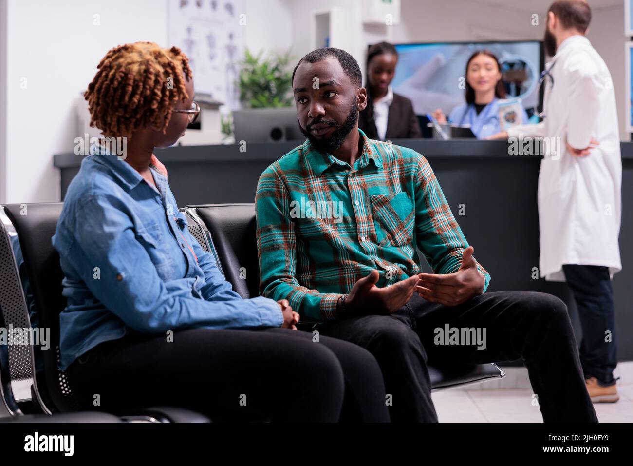 African american people talking in waiting area lobby, having medical ...