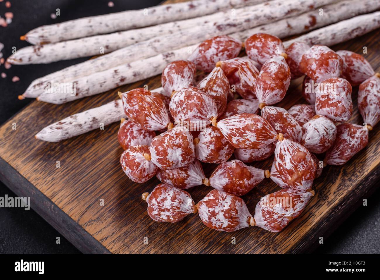 Spanish Fuet sausage slices, on a dark concrete background Stock Photo ...