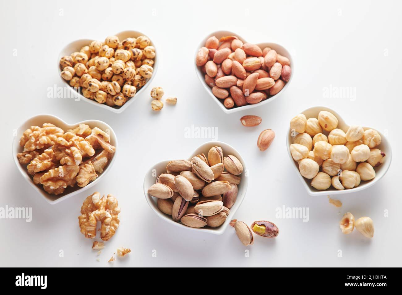 From above of assorted types of healthy nuts served on ceramic heart ...