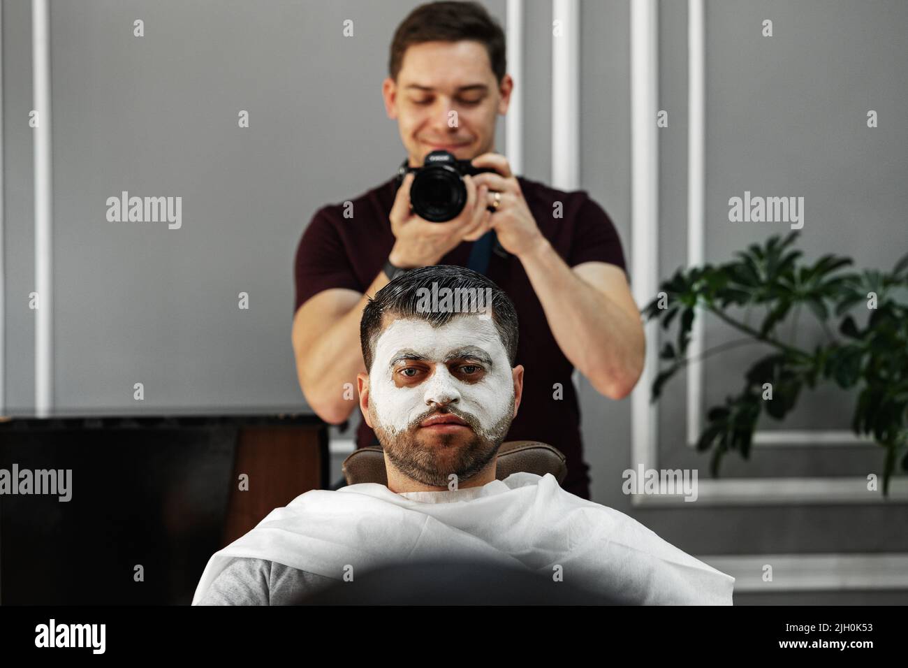 Relaxed man having purifying mask on face in a barbershop Stock Photo ...