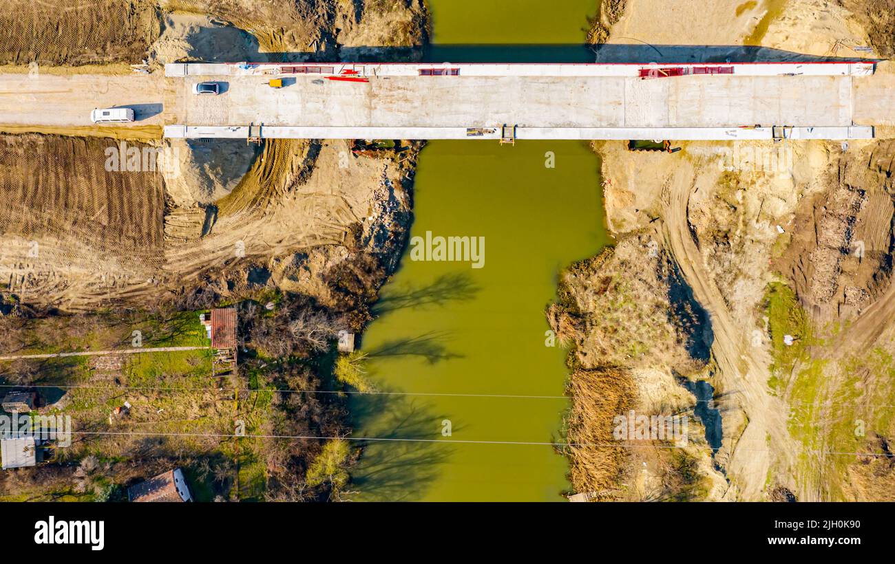 Above top view, overhead, on unfinished bridge, road over river under ...