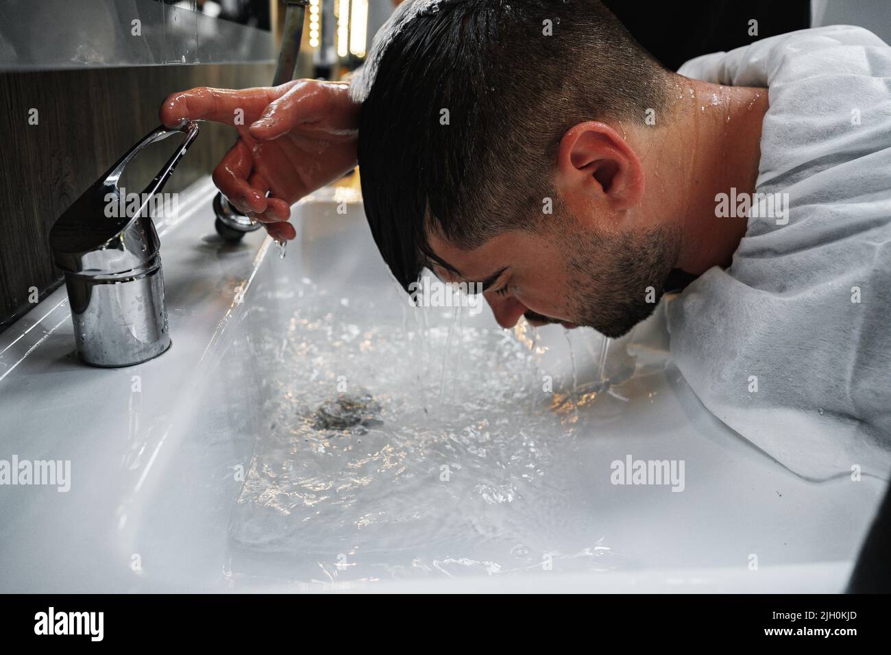Hairdresser washes man head hi-res stock photography and images - Alamy
